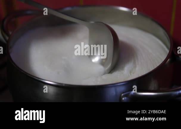 Milk boils and steams hot. Boiling milk in a stainless steel vessel ...