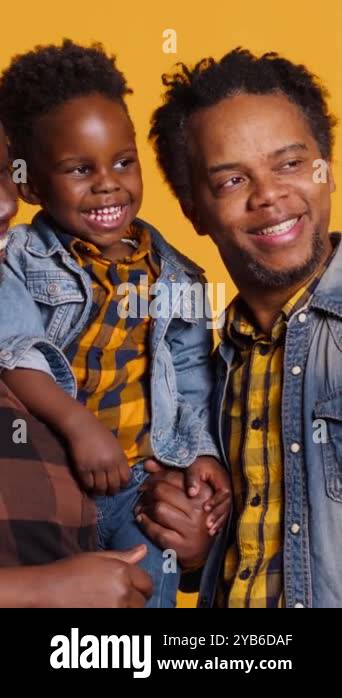 Vertical Video Mother and father taking photos with their cute toddler ...