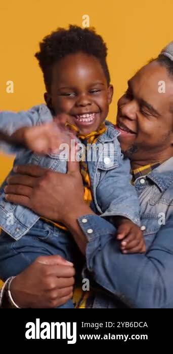 Vertical Video African american father and cute toddler having fun together in studio, dad ...