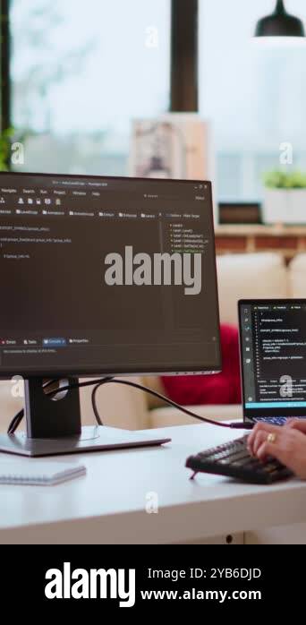 Vertical Video IT Specialist Types Code On Dual Monitors In A Cozy Home Office While Working