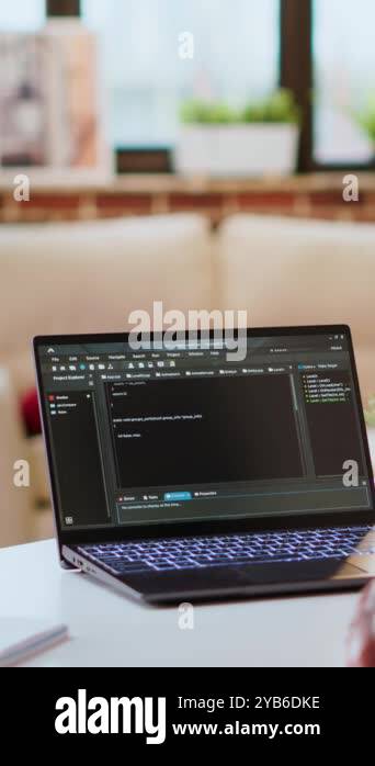 Vertical Video Male programmer developing an app on his laptop and working remotely. Home office ...