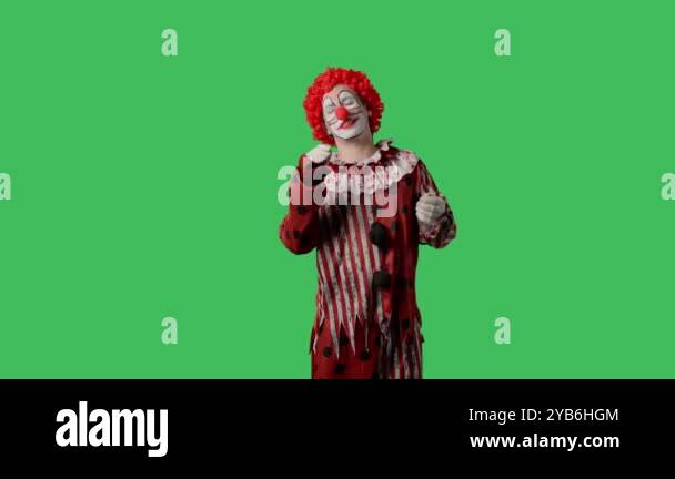 Funny clown on green screen chroma key. Actor man in red wig and suit ...