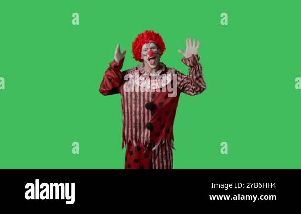 Funny clown on green screen chroma key. Actor man in red wig and suit ...