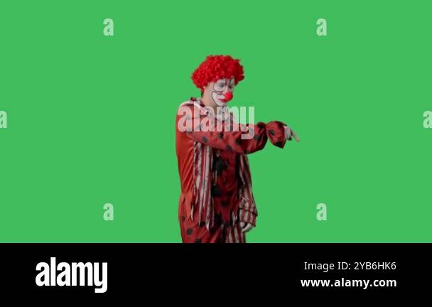 Funny clown on green screen chrome key. Actor man in red wig and suit ...