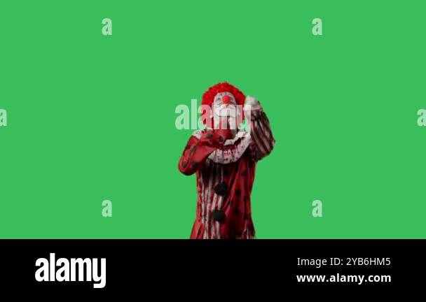 Funny clown on green screen chroma key. Actor man in red wig and suit ...
