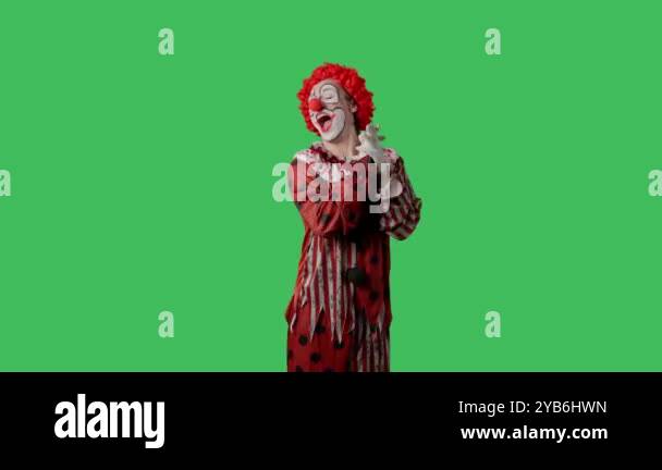Funny clown on green screen chroma key. Actor man in red wig and suit ...
