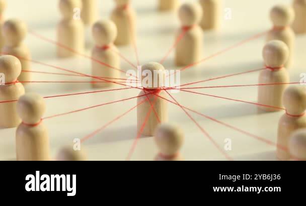 Wooden figures of society people connected by a network of red threads ...