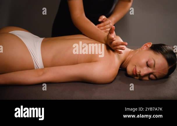 A professional massage therapist works on a womans back, offering a calming and therapeutic ...