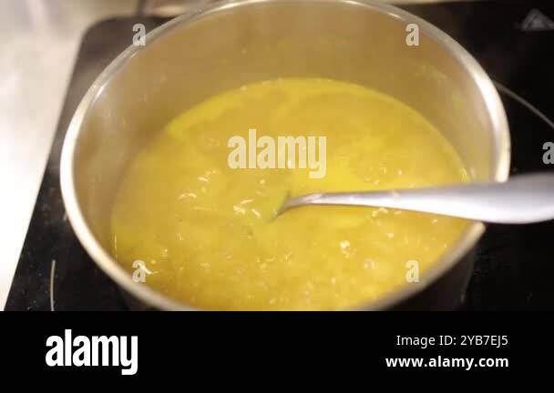 Yellow sauce, stainless pot, induction stovetop. Stainless steel pot ...