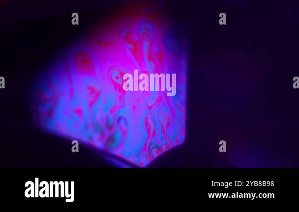 Red Purple multi-colored liquid in macro, color change and reflection ...