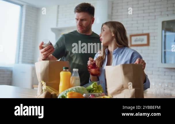 Closeup pair sorting food together in kitchen. Family taking purchased ...