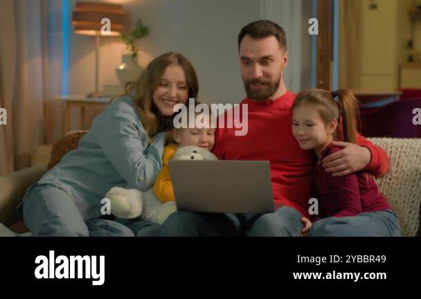 Caucasian family parents children on couch evening home teach little ...