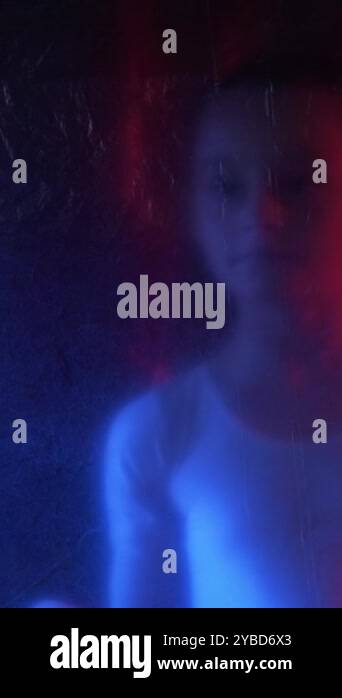 Vertical video. Sad girl. Blur silhouette. Neon portrait in dark red ...