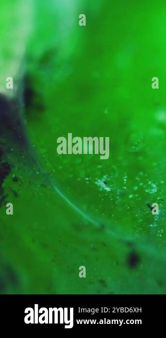 Vertical video. Bubble float. Glitter fluid. Defocused green acid black ...