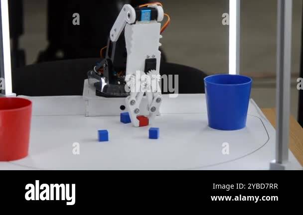 Robot automatic hand taking cubes and putting in glass. Automatic robotic arm distinguishing ...
