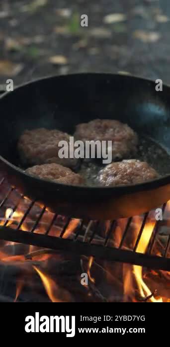 Vertical footage of cooking American fat smash burgers on pan. Beef or ...