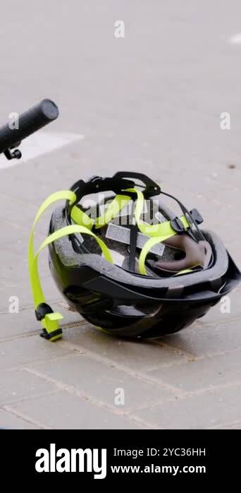 Helmet lies near overturned scooter on pavement indicating recent ...