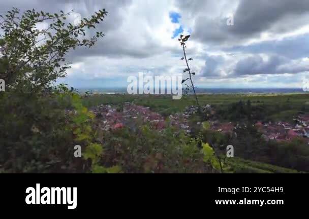 This stunning view showcases a vibrant landscape filled with rich greenery beneath a sweeping ...