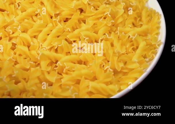 Uncooked Fusilli Pasta on White Plate Rotating against Black Background ...