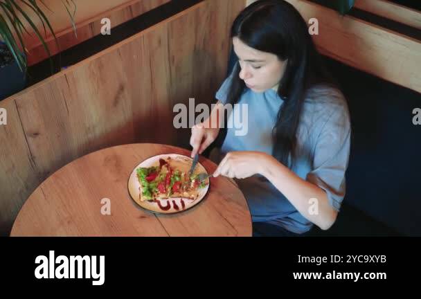 A serene moment of mindful eating as a woman enjoys her healthy meal at ...
