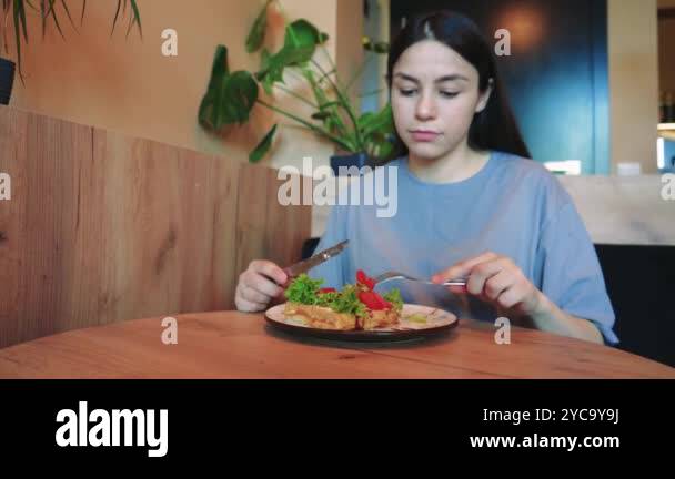 A peaceful indoor dining scene, featuring a woman enjoying a light meal ...