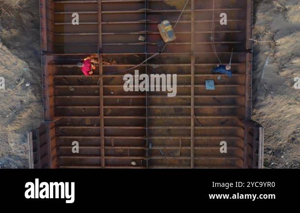 Above top view on workers as they cutting old large vessel, barge ...