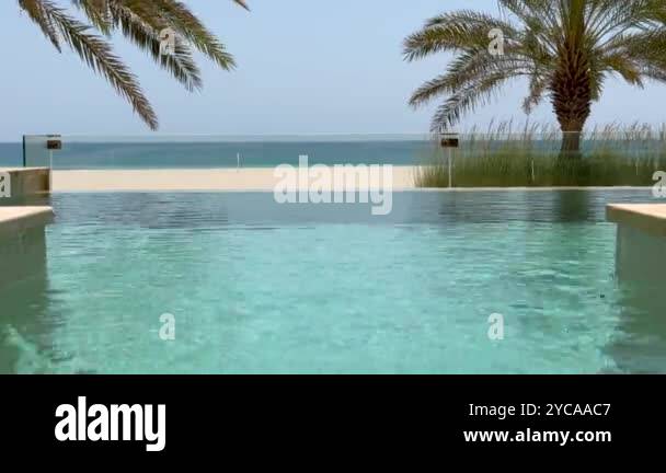 Turquoise swimming pool at luxury tourist resort, surrounded by shiny ...