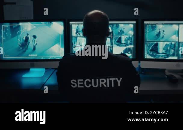 Medium rear shot of black male security guard with bald head, in ...