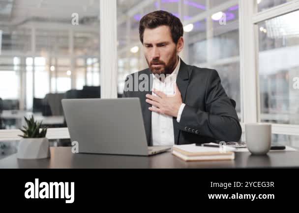 Businessman having chest pain or heart attack at work. Man working on a ...