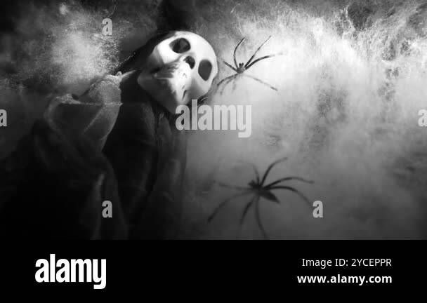 Haunting Halloween setting, a skull skeleton lies among eerie cobwebs ...