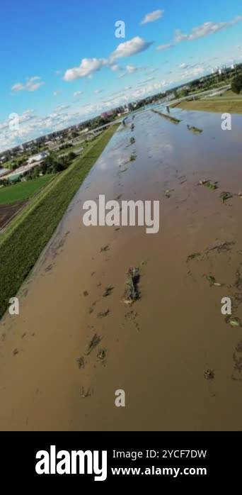 The video shows aerial footage of a river that has burst its banks and ...