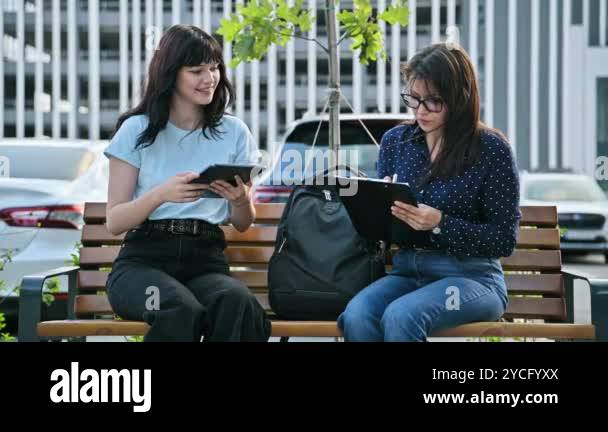 College student girl and female teacher mentor social worker talking working together sitting on ...