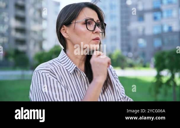 Sad upset stressed mature woman, outdoor portrait. Middle aged serious ...