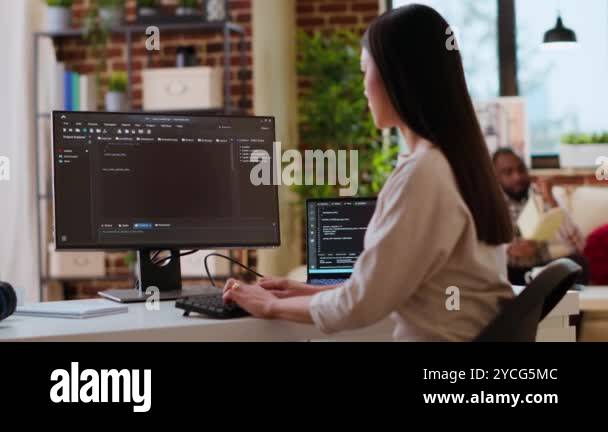 Asian female developer coding cloud computing applications on pc in a modern tech workspace ...