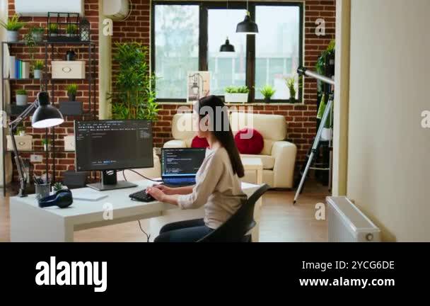 Asian Programmer Seen Typing Code For A User Interface Design On Dual Monitors Working In A