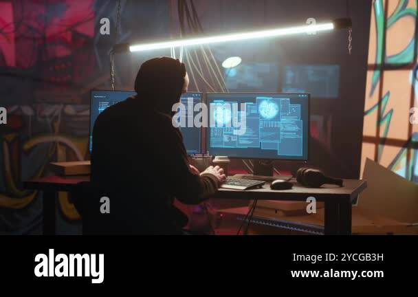 Hacker using high tech computer system to run malicious code in foggy dark basement. Rogue ...