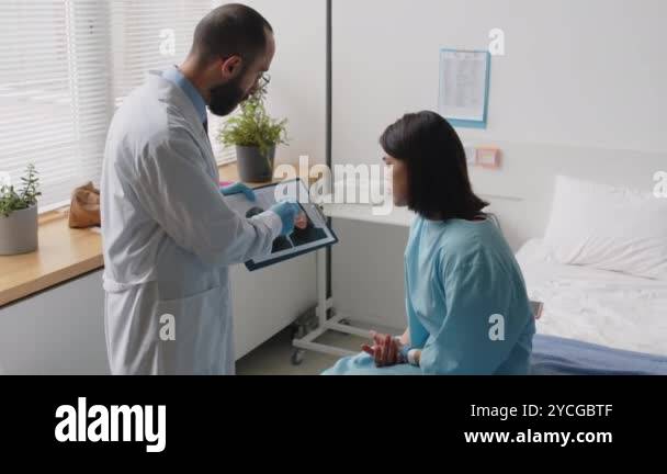 Plastic surgeon showing young female patient images of before-and-after ...