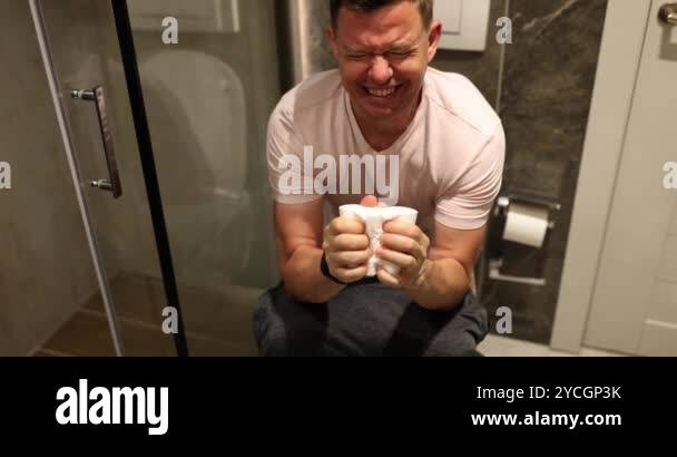 Man with problem sitting on toilet closeup. Constipation diarrhea and ...