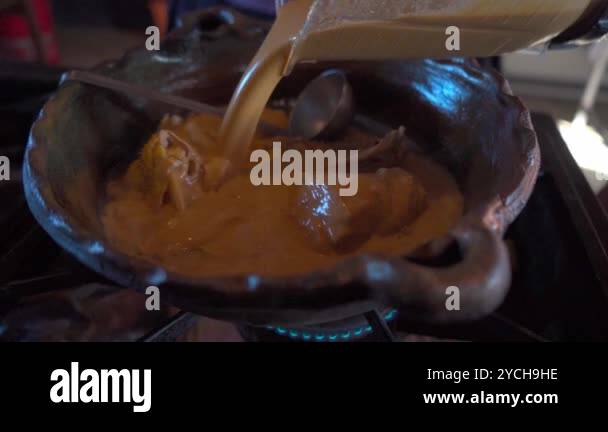 Process of cooking chicken in a clay pot, while adding recado. The ...