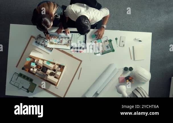 Top view of architect engineer sitting while explain house plan to ...