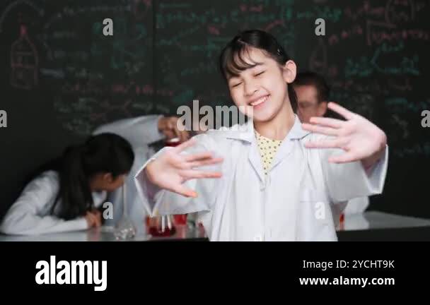 Cute asian scientist waving hand to camera while diverse group doing ...
