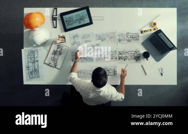 Top down aerial view of architect engineer placing building blueprint ...
