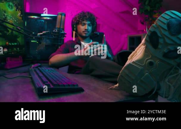 Indian Muslim man gamer streamer influencer in headphones put feet on ...