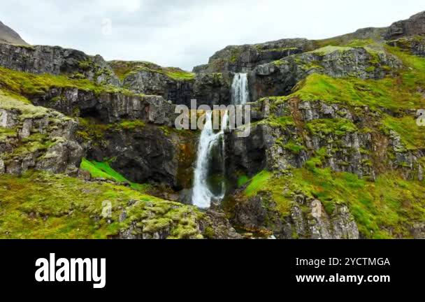Wispy waterfalls flowing over cliff, Mountain river falling over cliff ...