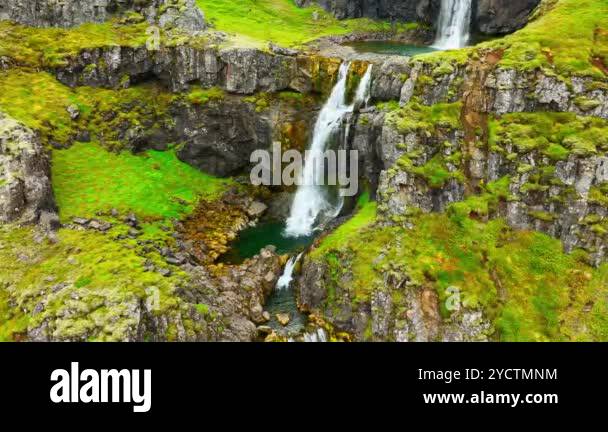 Wispy waterfalls flowing over cliff, Mountain river falling over cliff ...