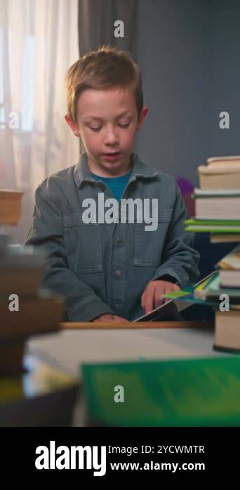 Focused Schoolboy Reading a Book at Home While Doing Homework and ...