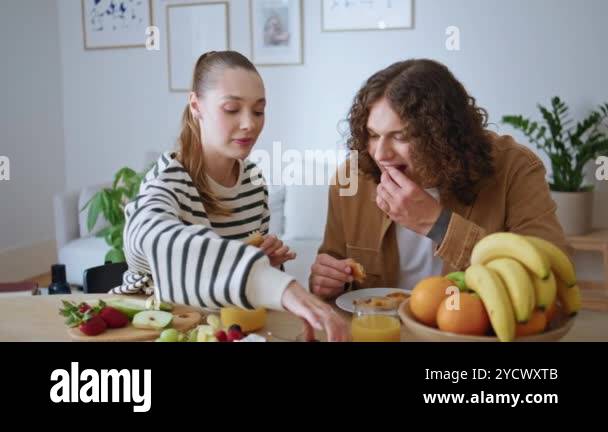 Romantic pair enjoy breakfast together in modern kitchen. Smiling woman ...