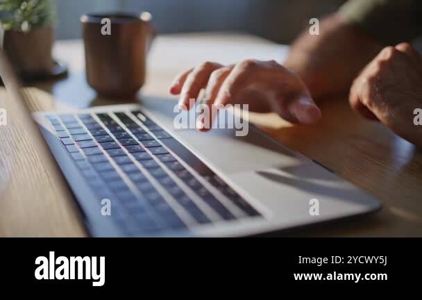 Freelancer hand swiping laptop touchpad in sunshine room closeup ...