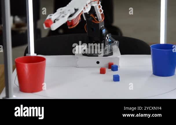 Robot automatic hand taking cubes and putting in glass. Automatic robotic arm distinguishing ...