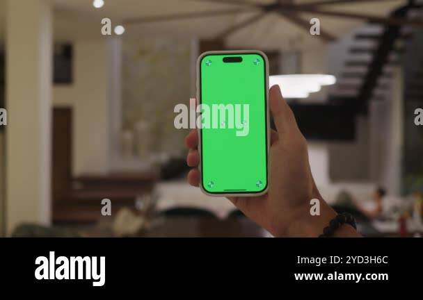 Chroma key technology in action hand holding smartphone with green ...